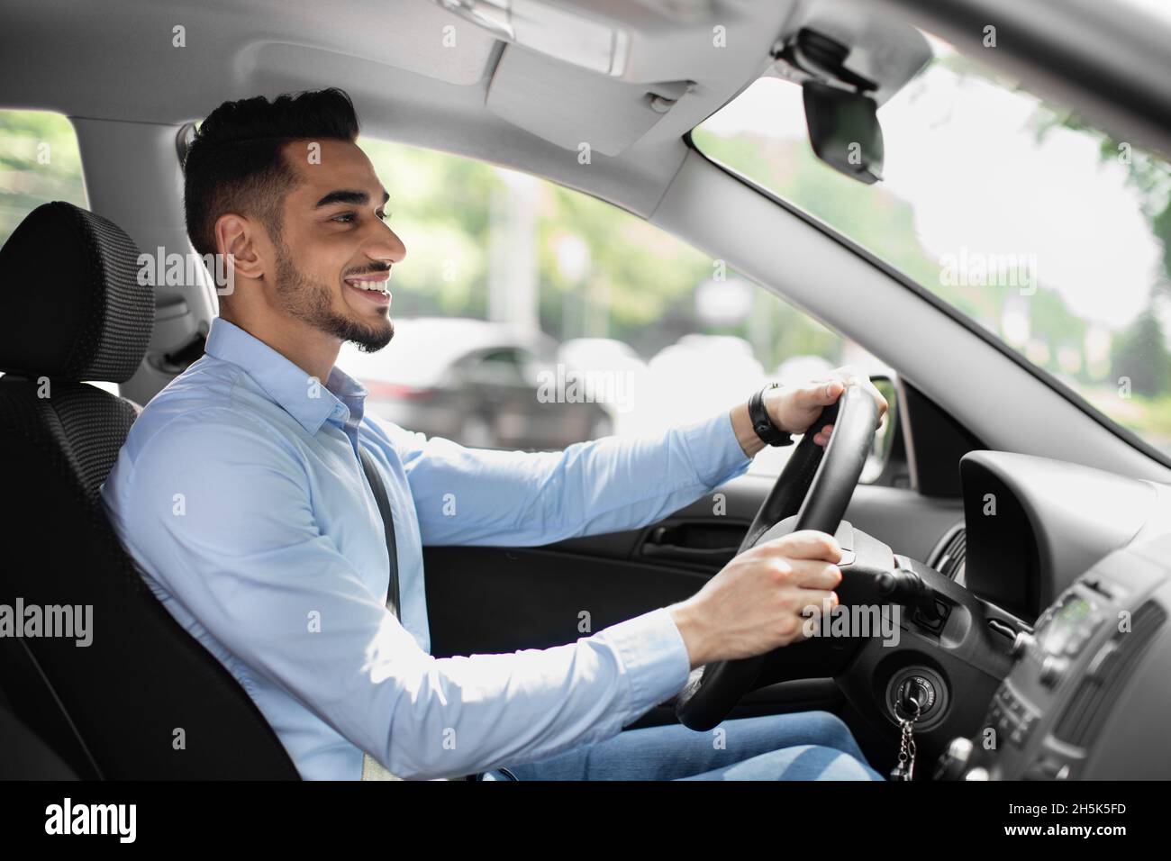 Joyeux barbu arabe gars dans la tenue formelle regardant la route et ...