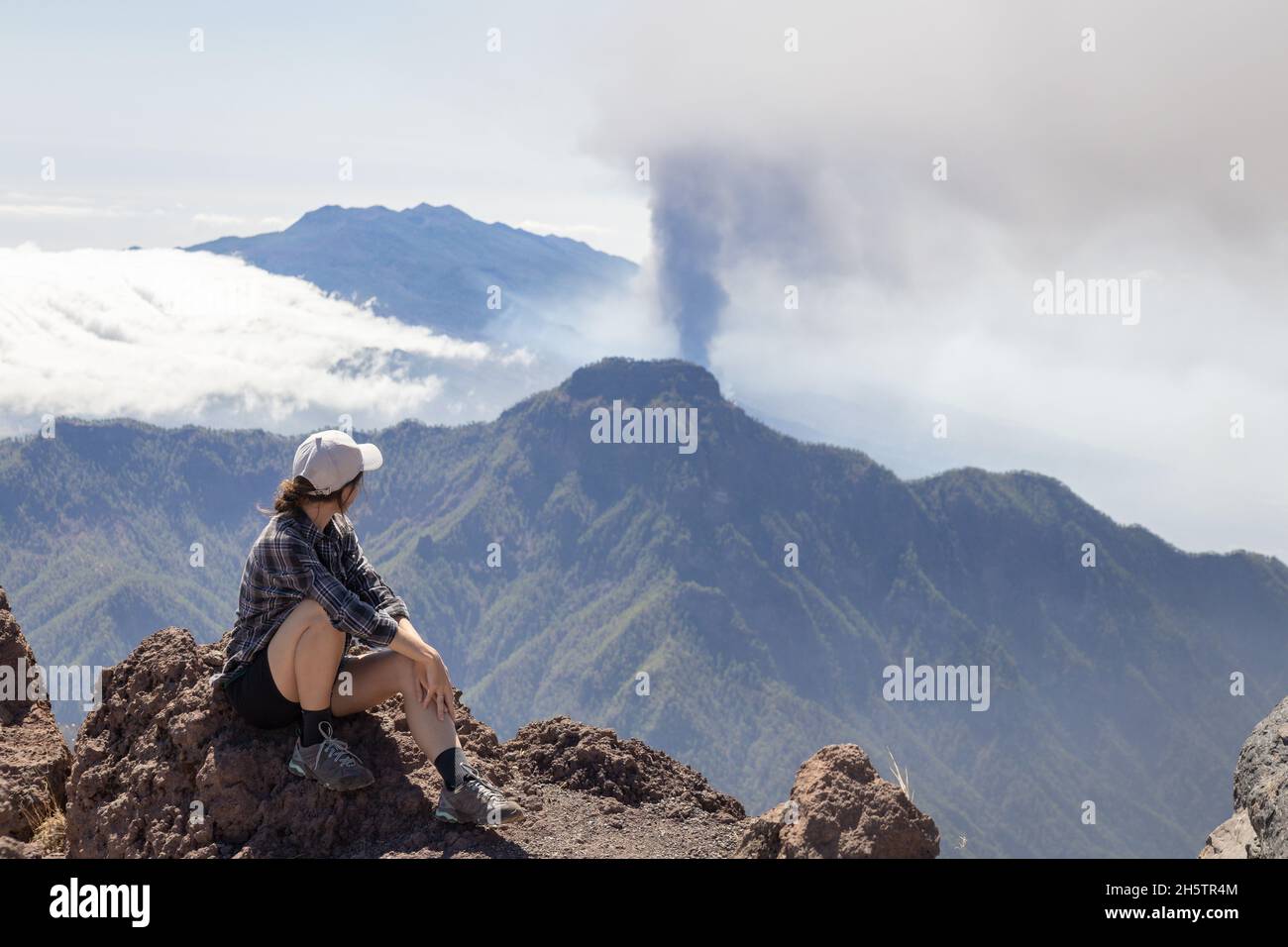Une jeune fille de touristes regardant l'éruption volcanique de Cumbre ...