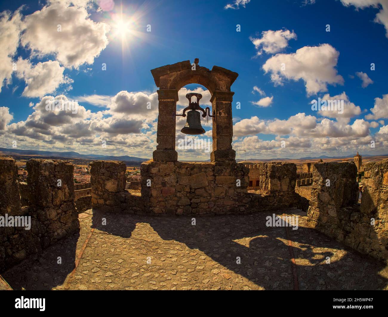 Arche en pierre avec une grande cloche sur le mur du château de ...