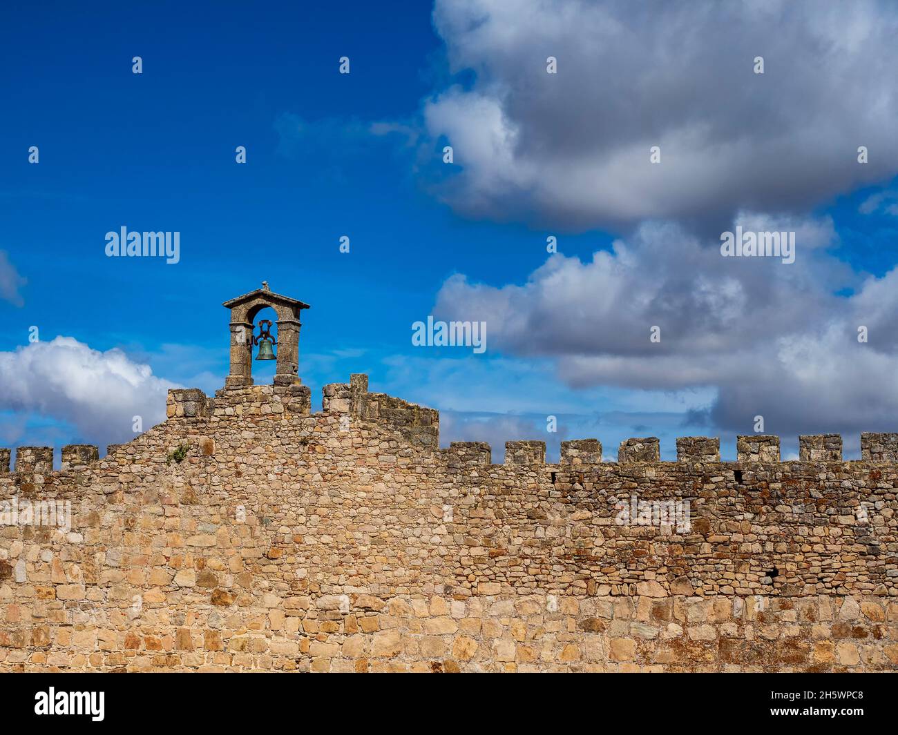 Arche en pierre avec une grande cloche sur le mur du château de ...