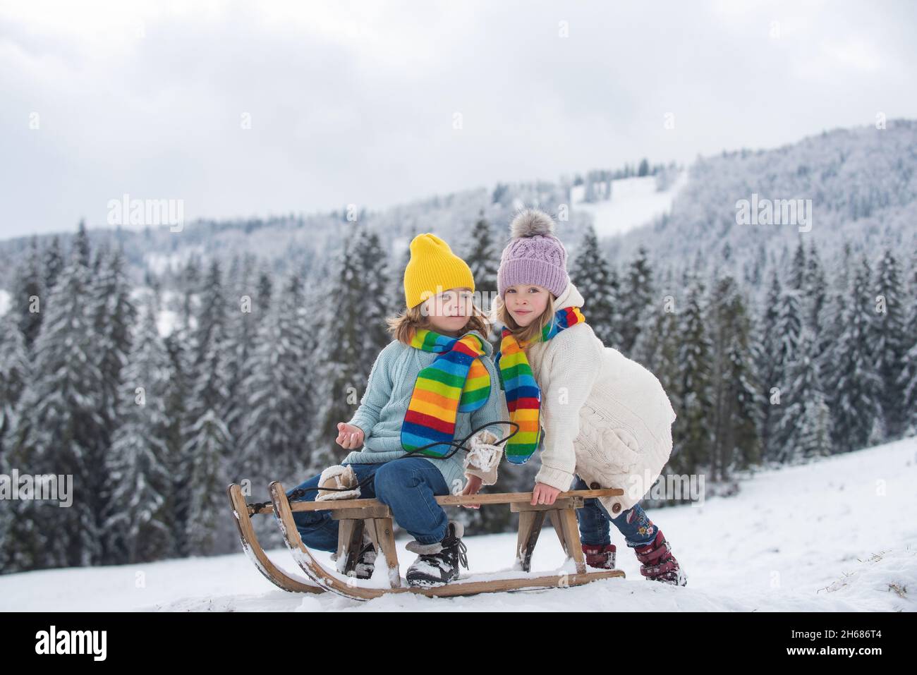 Un garçon et une fille se traînent en hiver.Enfants en train de monter ...