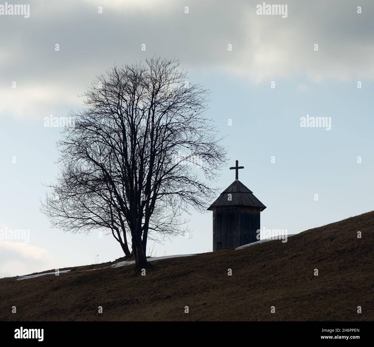 Paysage de printemps.Chapelle en bois et arbre sur une colline.Village ...