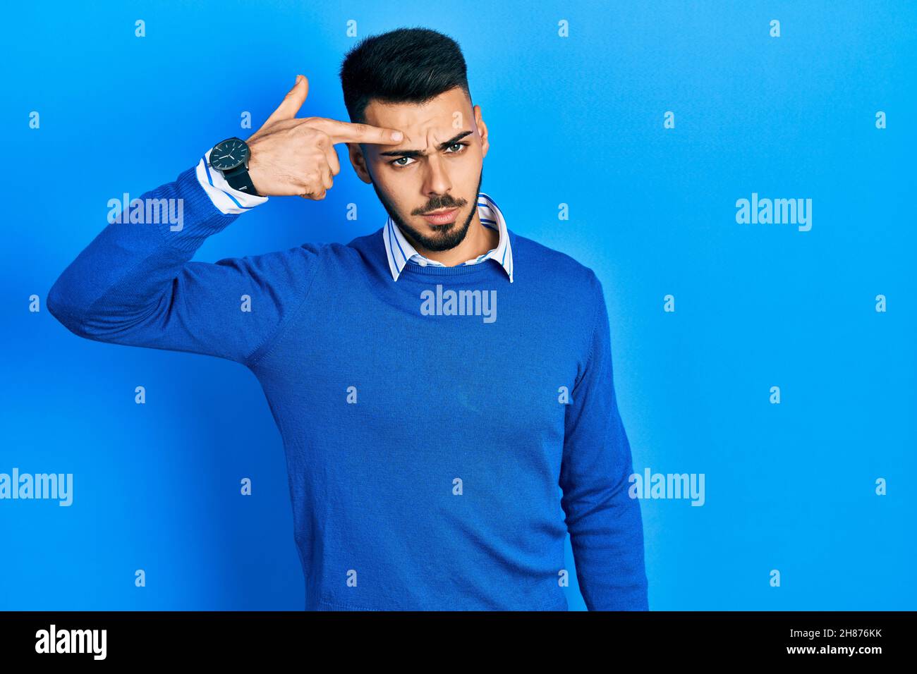 Jeune homme hispanique avec la barbe portant un chandail bleu ...