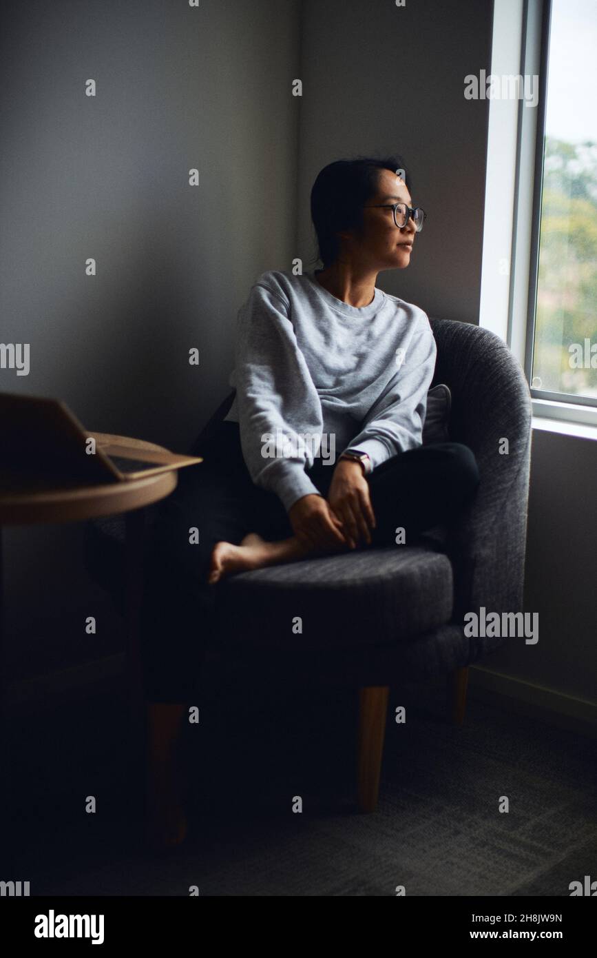 Femme assise dans un fauteuil Banque de photographies et d’images à haute résolution - Alamy