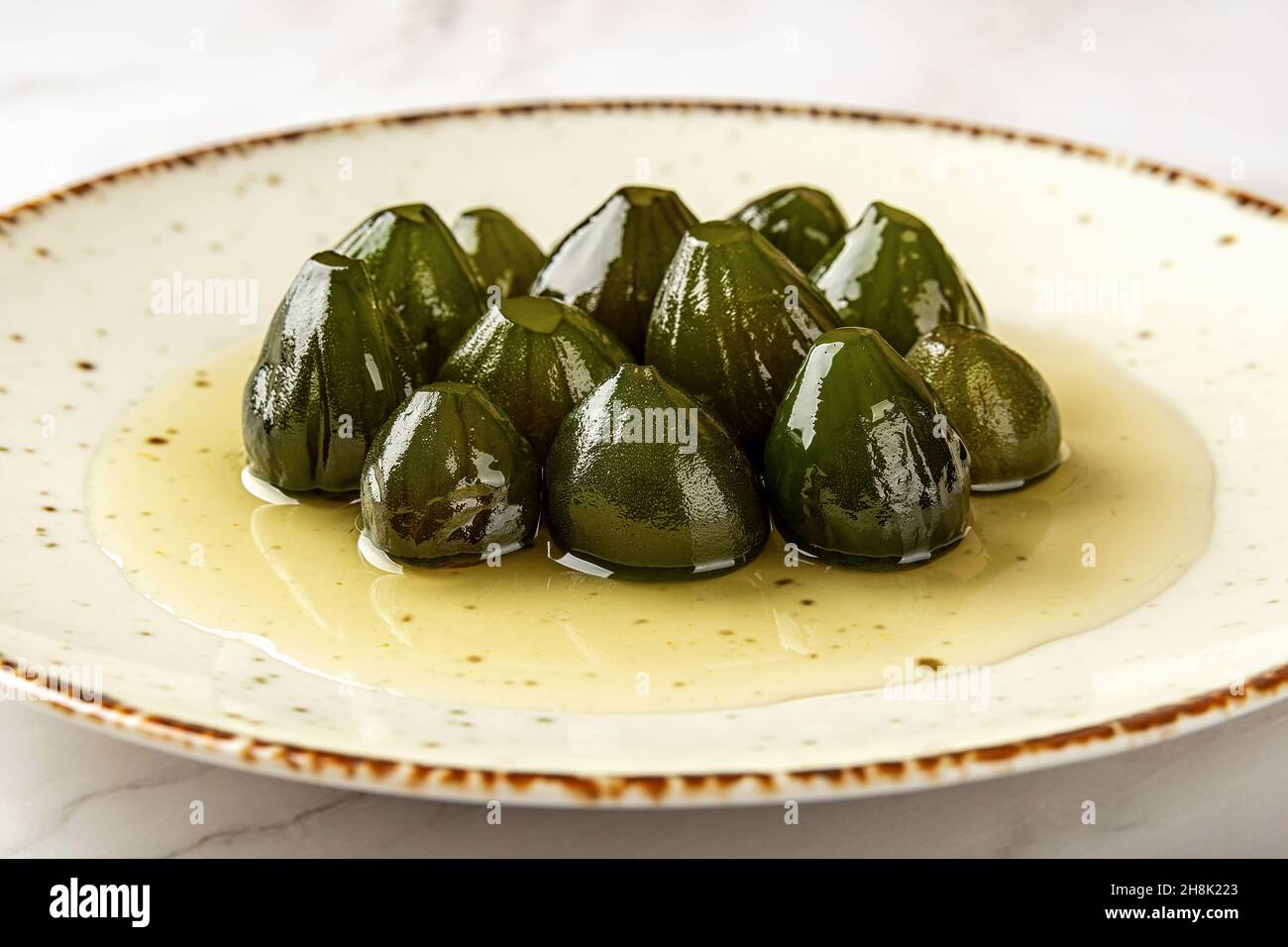 Délicieuses figues entières non mûres au sirop sur une assiette en ...