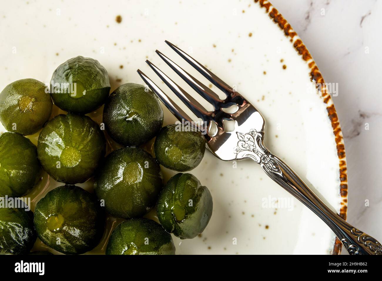 Vue de dessus des figues vertes entières conservées et de la fourchette ...