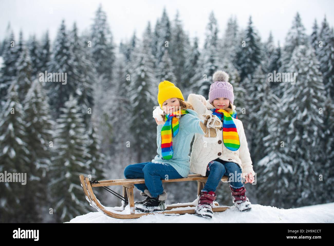 Un garçon et une fille se traînent en hiver.Enfants en train de monter ...