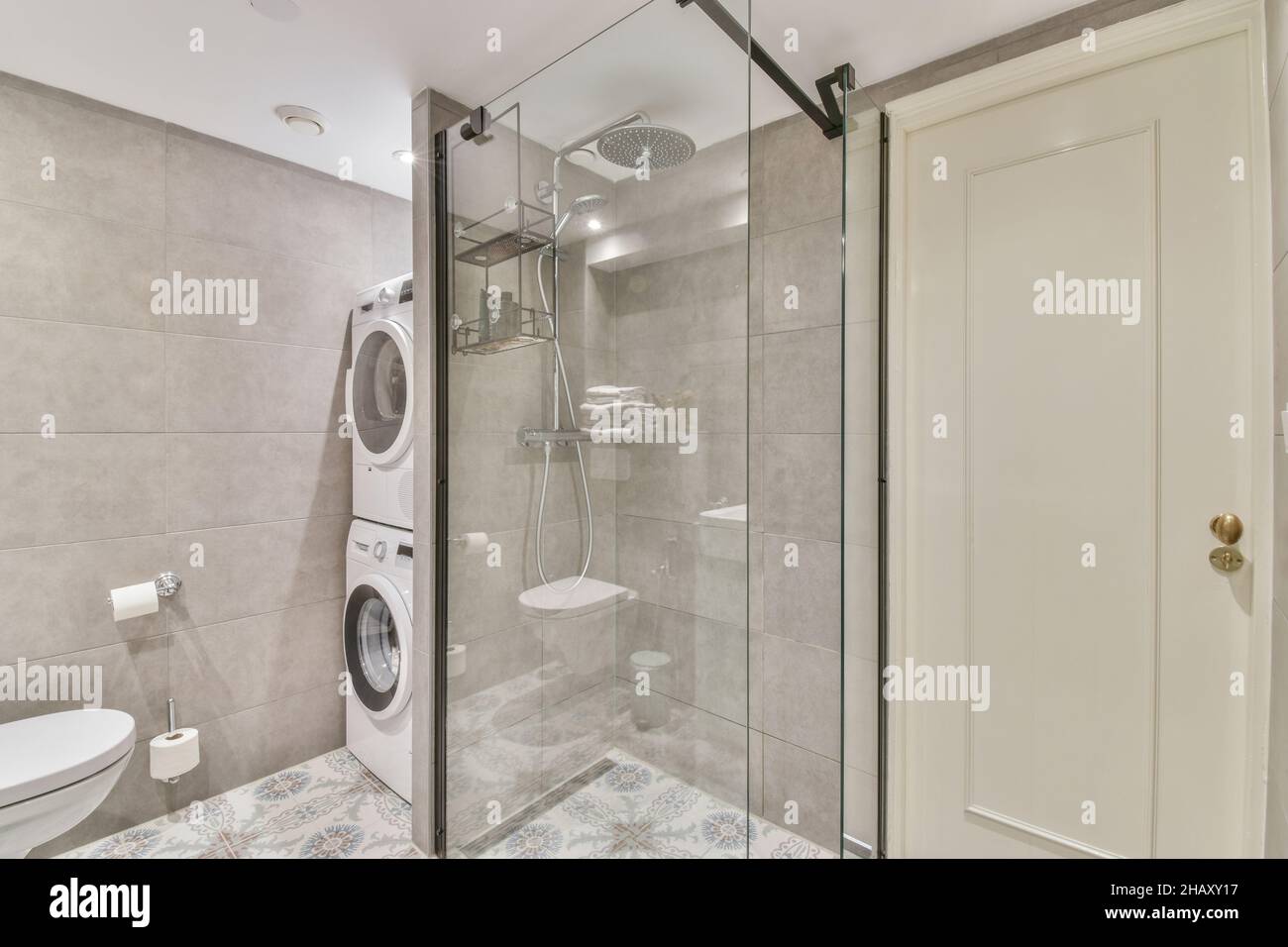 Lave-linge et sèche-linge blancs placés près des douches avec murs en ...