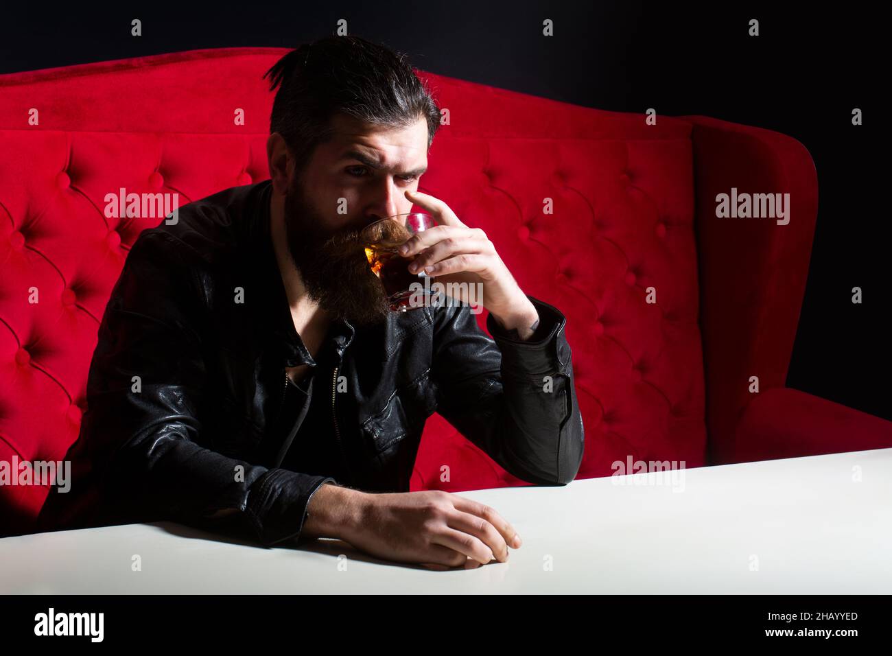 Homme barbu qui boit du whisky, du whisky ou du cognac.Hipster homme ...