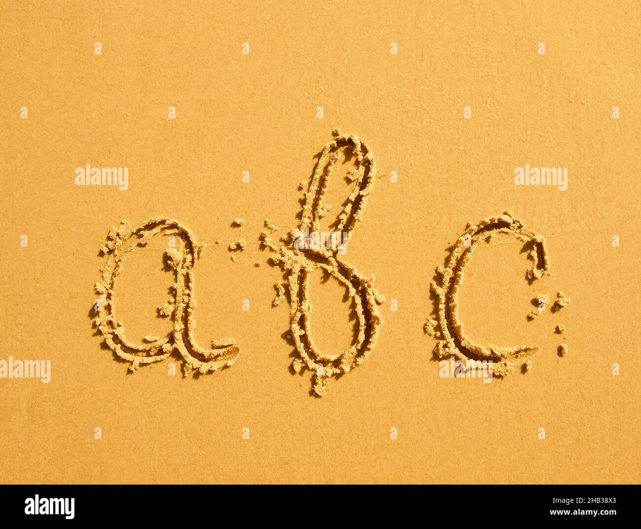 lettres de l'alphabet a b c manuscrites dans le sable sur la plage ...