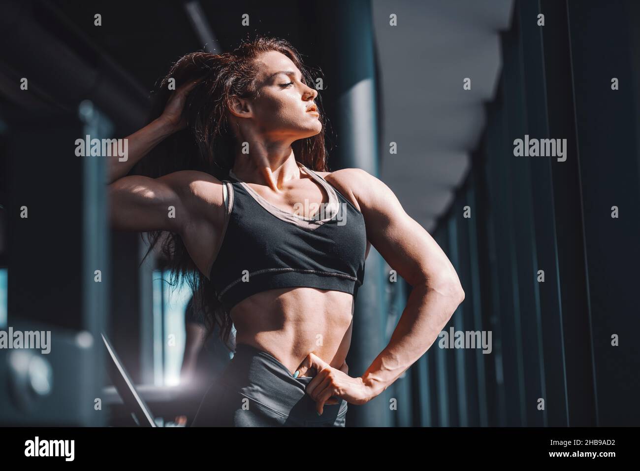 Portrait de la belle femme caucasienne culturiste posant dans la salle ...