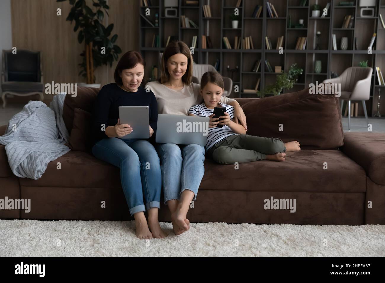 Vieille grand-mère jeune mère préteen fille tenir portable pavé tactile ...