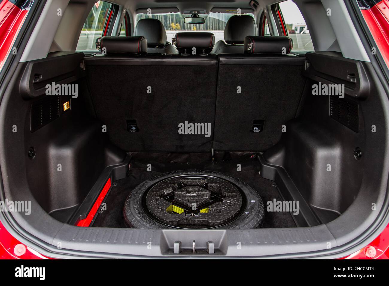 Roue de secours dans le coffre d'une voiture moderne.Soulevez le cric ...