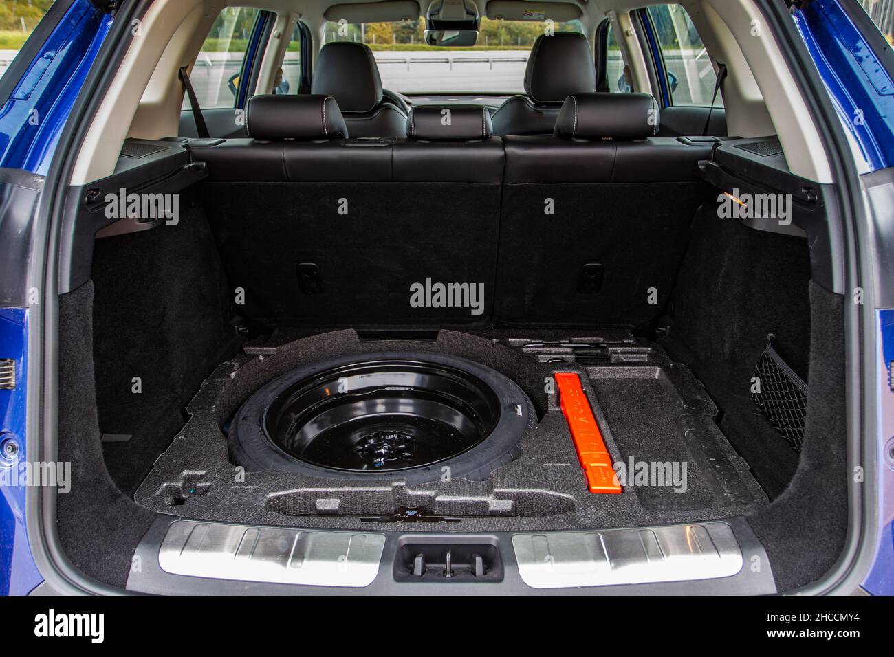 Roue de secours dans le coffre d'une voiture moderne.Soulevez le cric ...