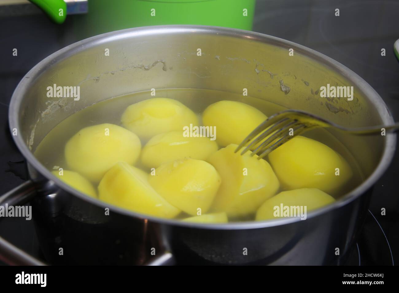 Gros plan de la casserole sur plaque chauffante avec des pots crus dans ...
