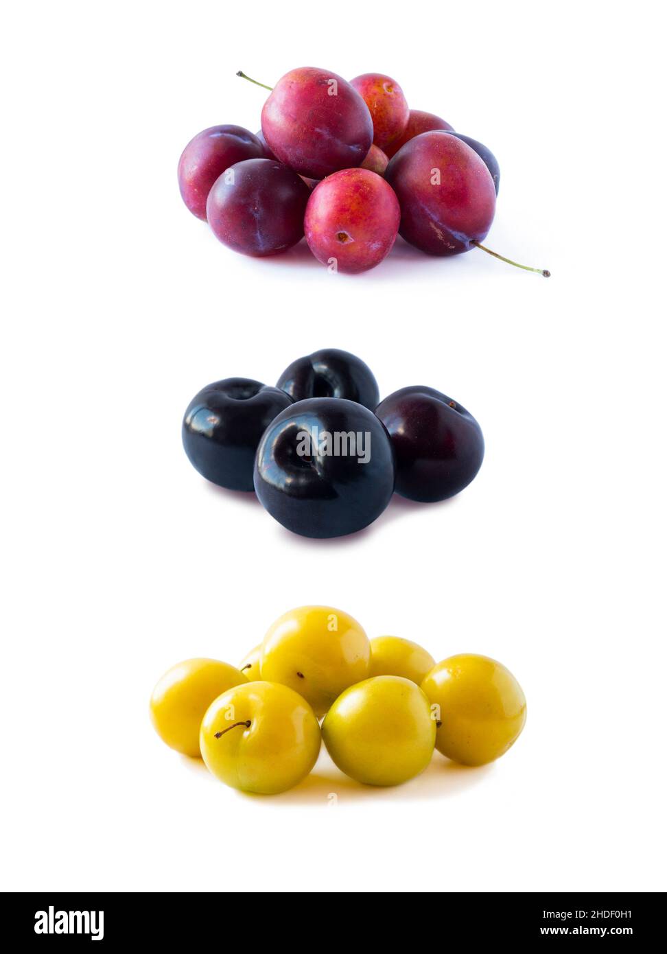 Tas de prunes coupées sur fond blanc.Un ensemble de prunes de ...