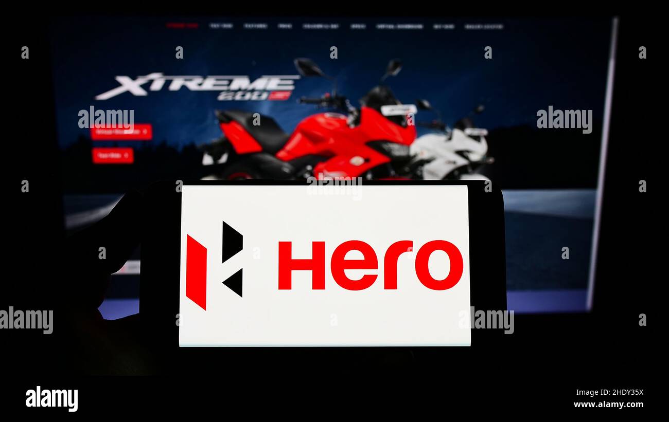 Personne tenant un smartphone avec le logo de la compagnie automobile indienne Hero MotoCorp ...