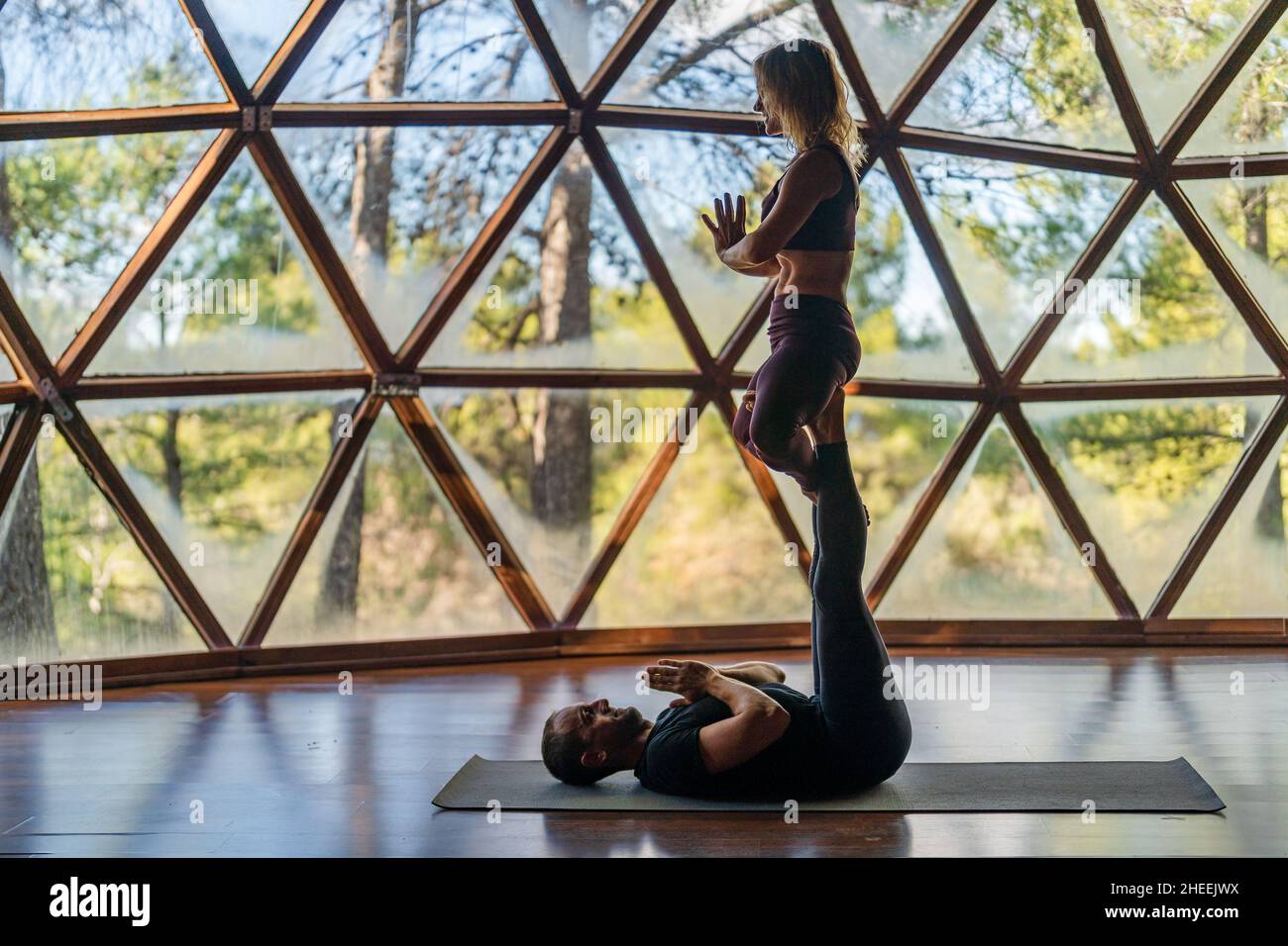 Vue latérale du corps du couple sportif en posture de yoga pendant qu ...