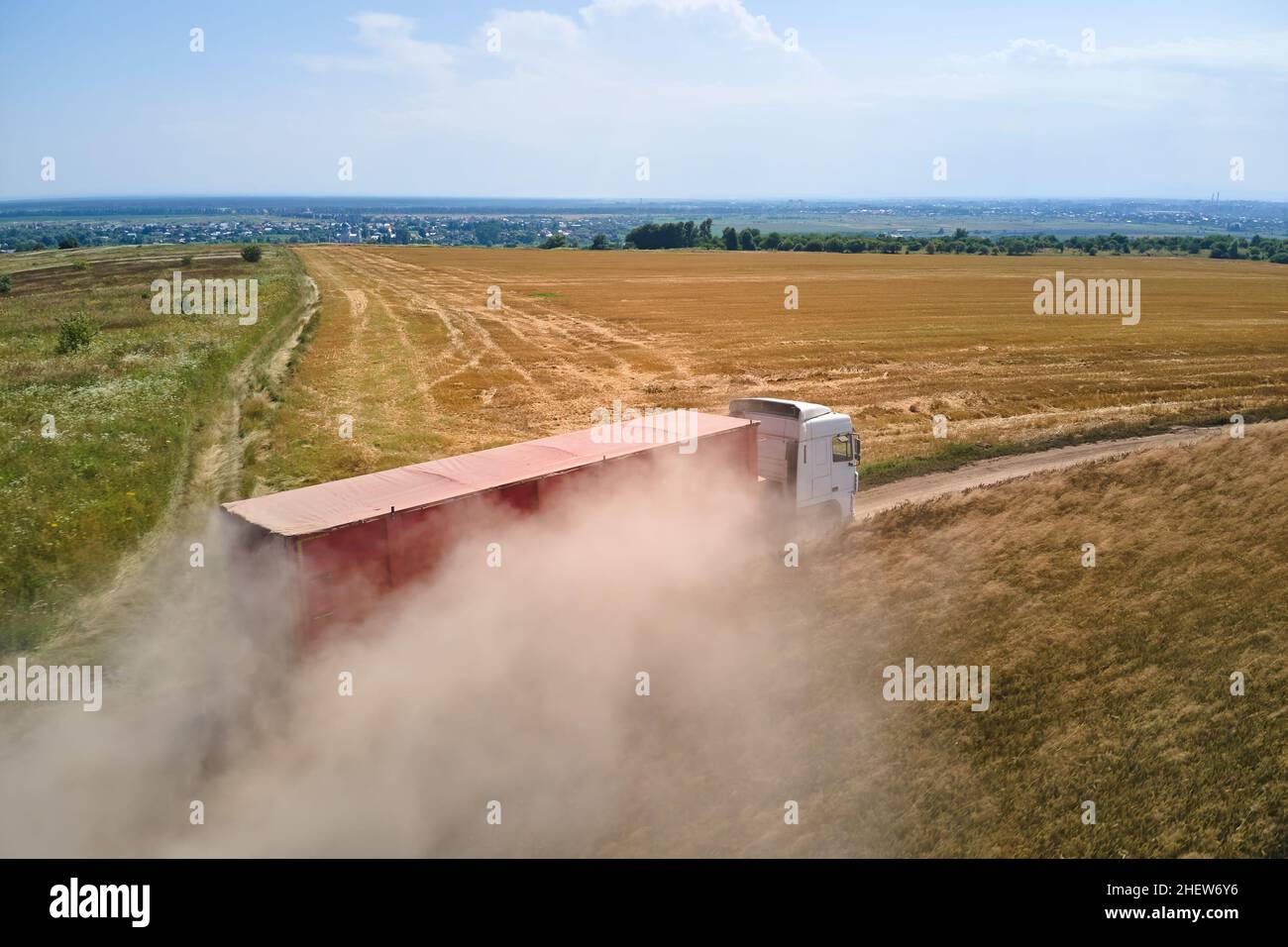 Vue aérienne d'un camion roulant sur route de terre entre les champs de ...