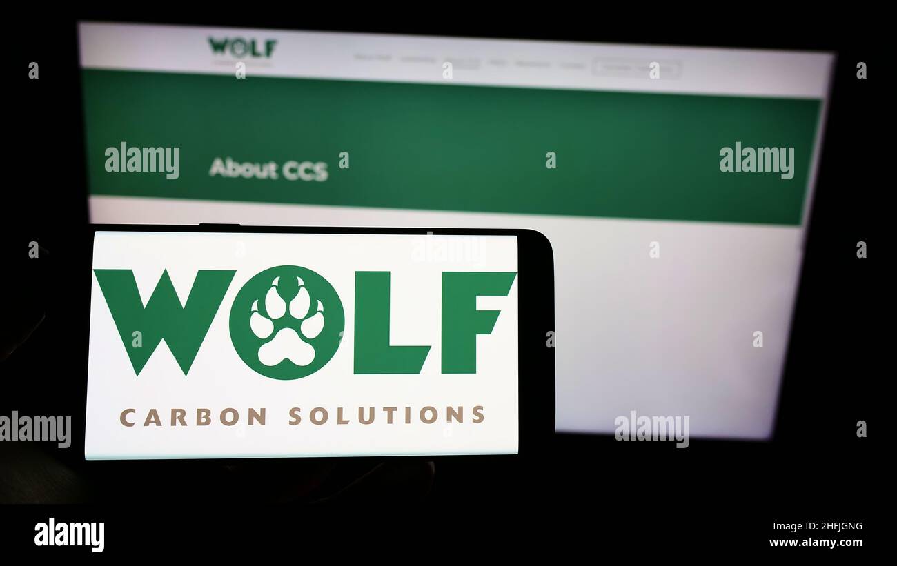 Personne tenant le téléphone portable avec le logo de la société Wolf Carbon Solutions sur l ...