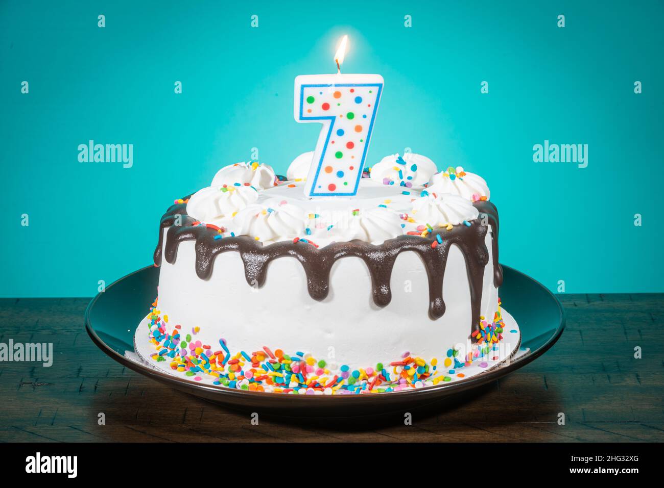 Un gâteau d'anniversaire porte une bougie en forme de numéro 7 Photo ...
