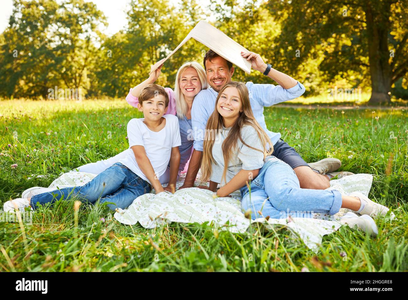 Famille heureuse avec deux enfants et toit sur leur tête comme symbole ...