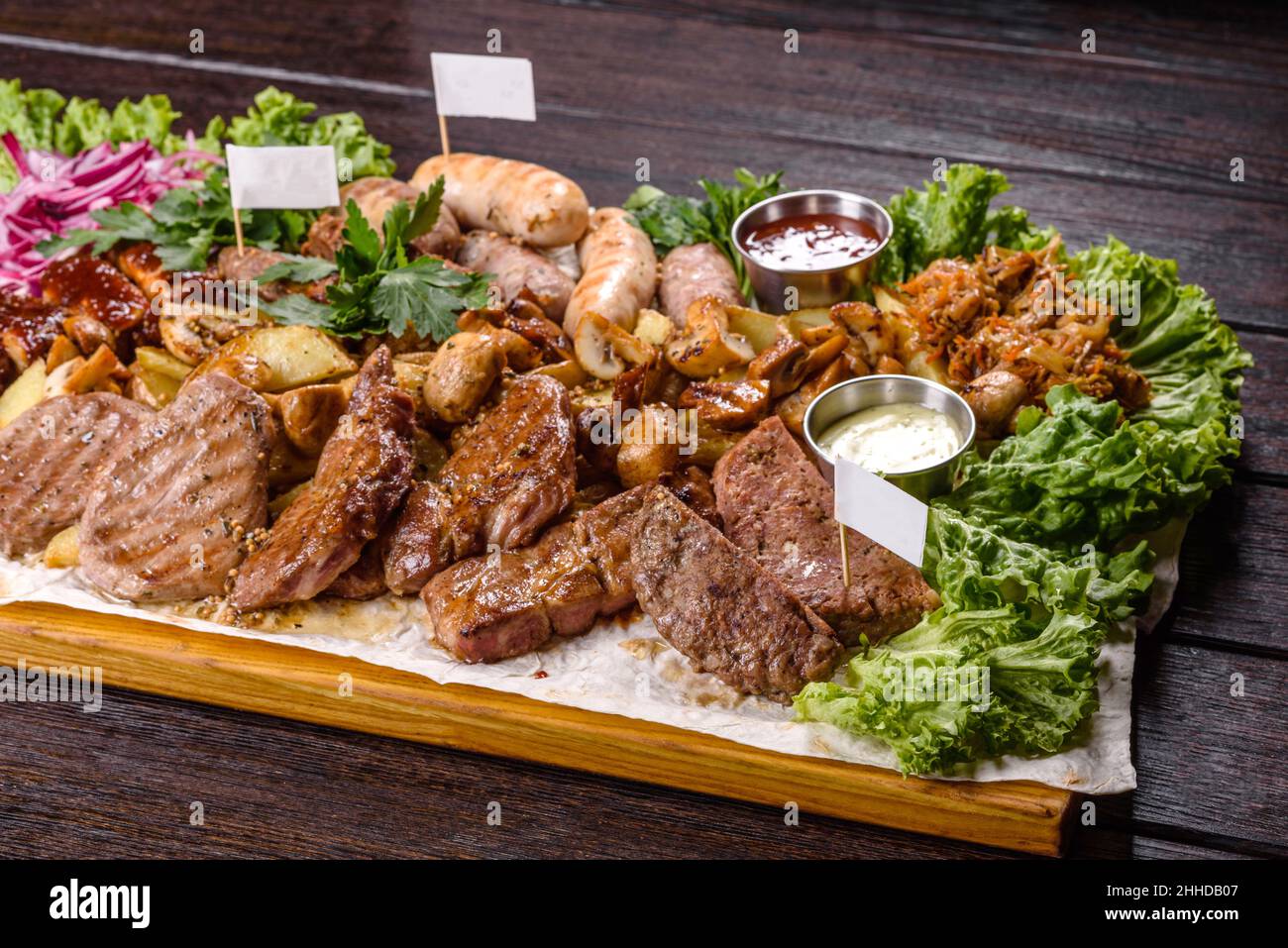 Plusieurs types de viande rôtie aux épices et aux herbes sur un plateau ...