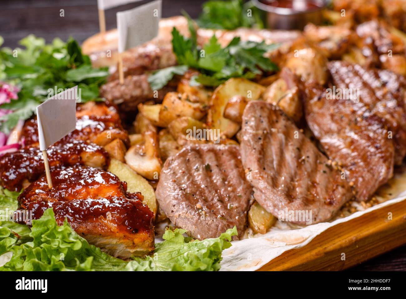 Plusieurs types de viande rôtie aux épices et aux herbes sur un plateau ...