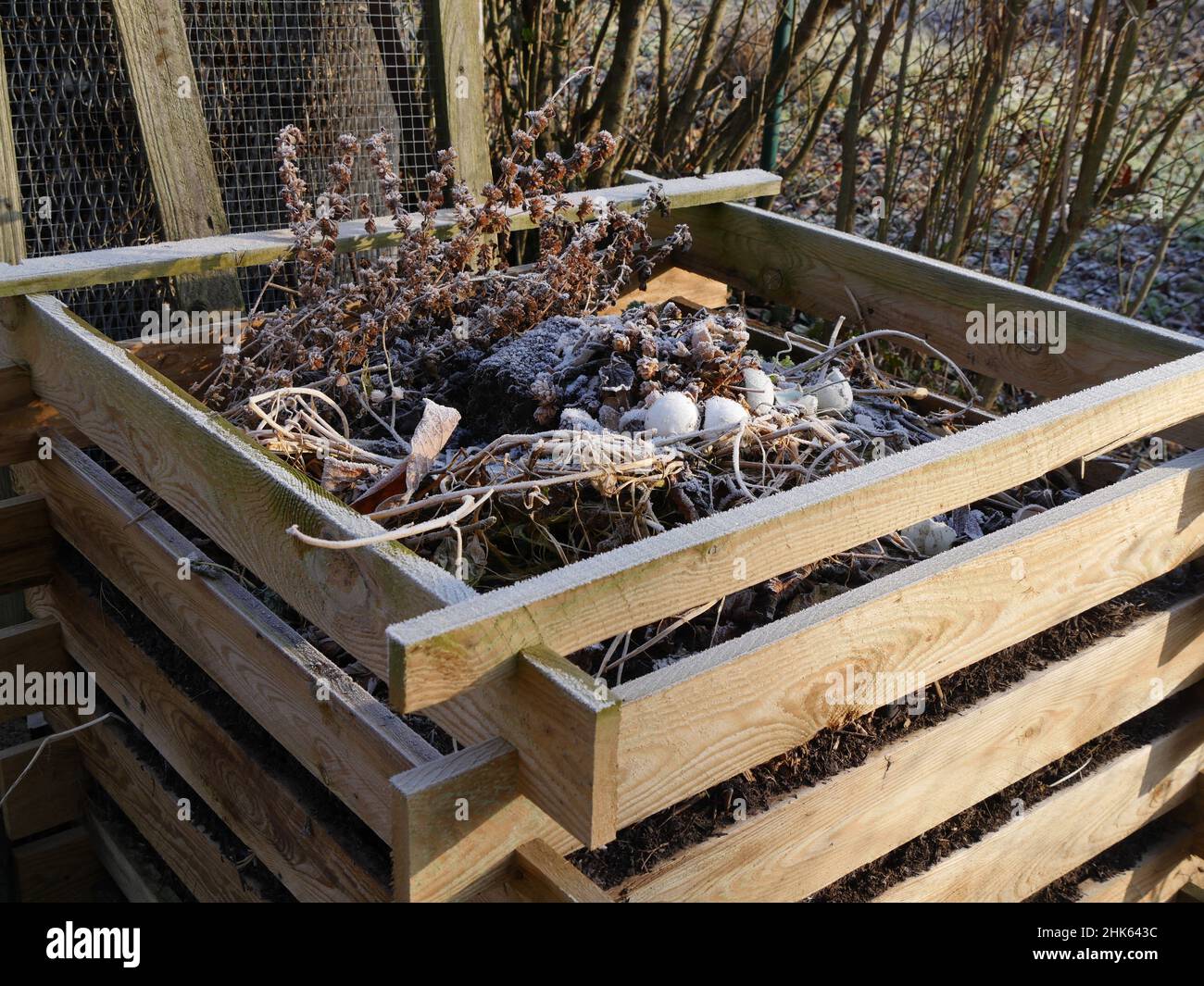 Boîte de compost en bois en hiver, derrière il y a Un tamis de compost ...