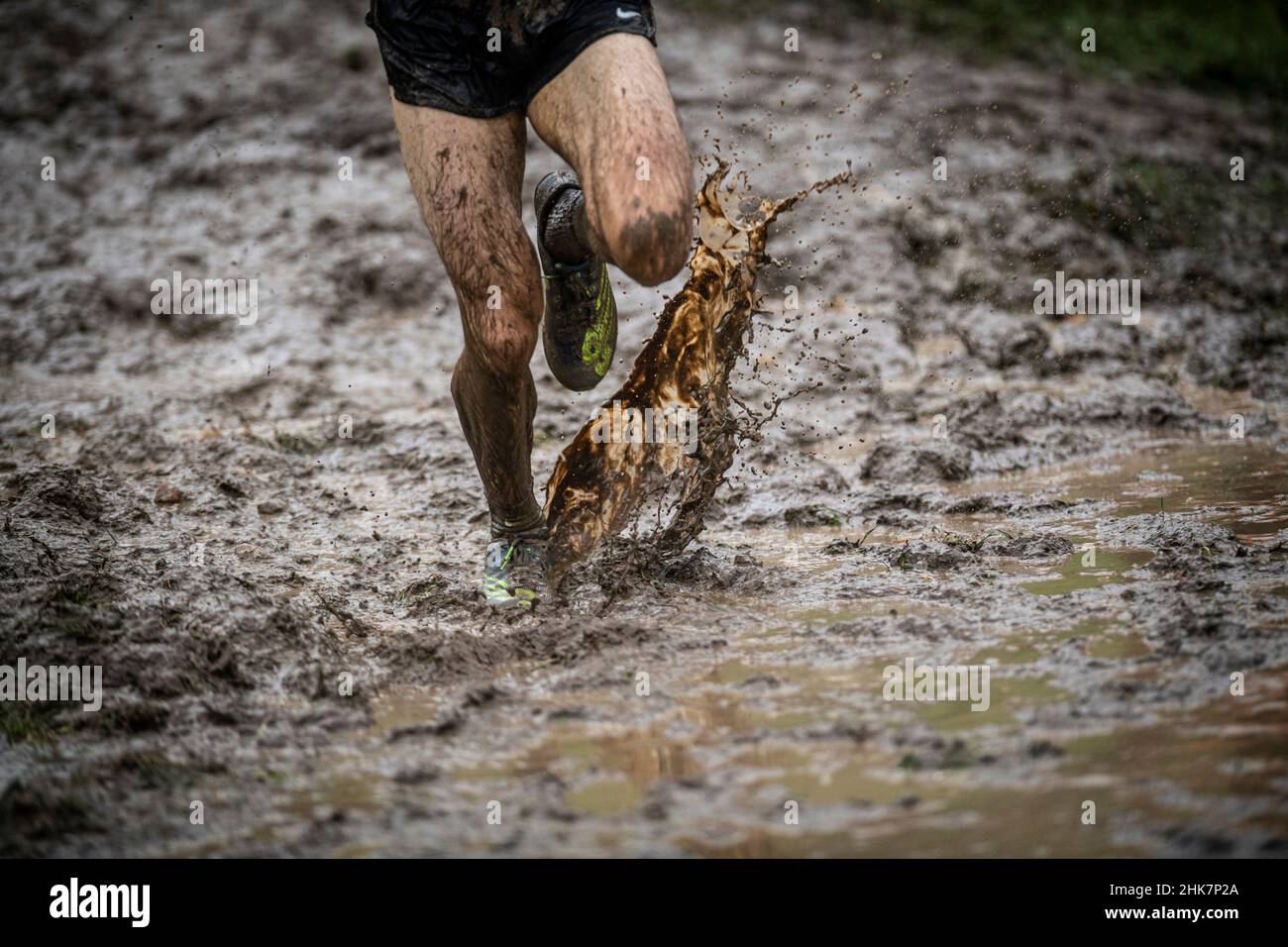 Les jambes de l'athlète courir dans un Cross Country entre l'eau et la boue, pure Cross Photo ...