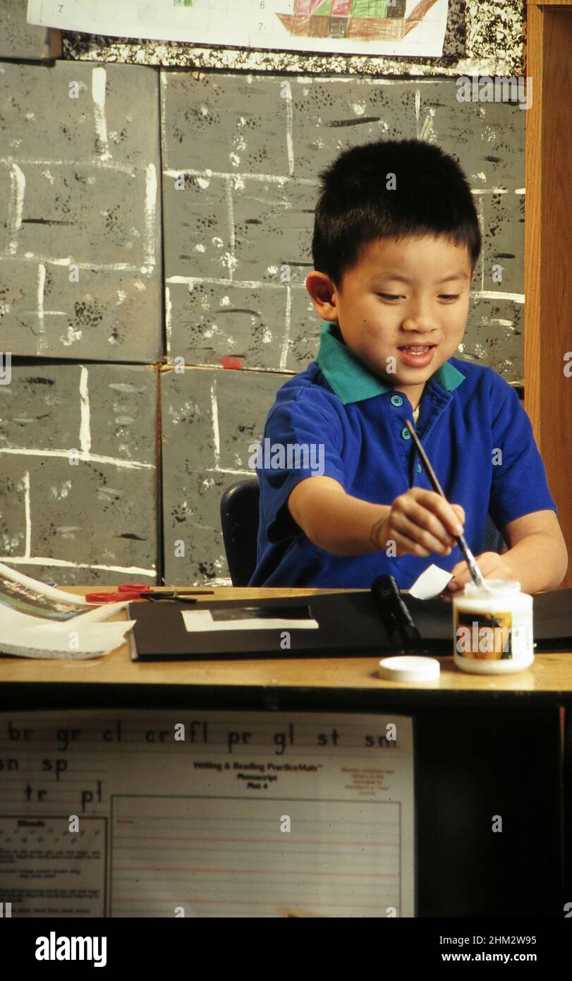 Garçon collant des images dans un album Banque de photographies et d ...