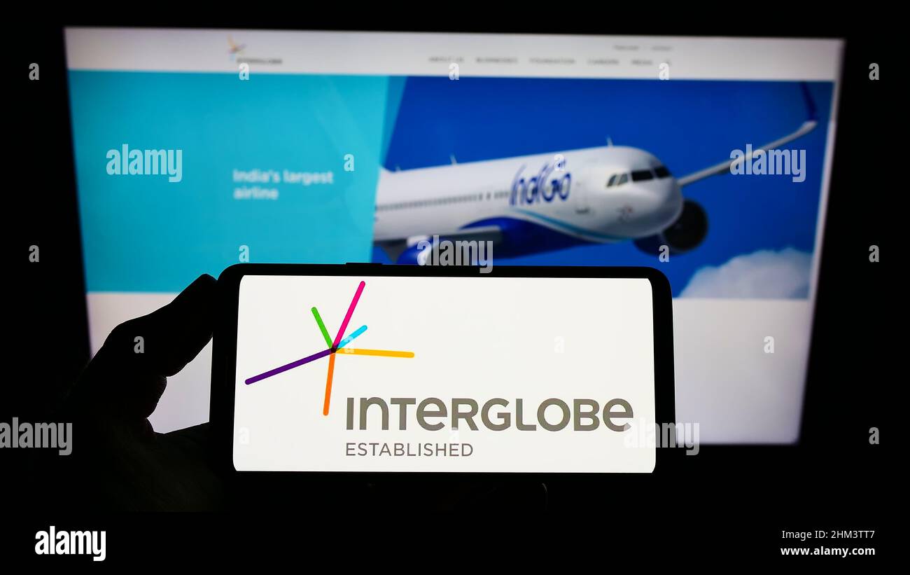 Personne tenant un smartphone avec le logo de la compagnie aérienne indienne InterGlobe Aviation ...