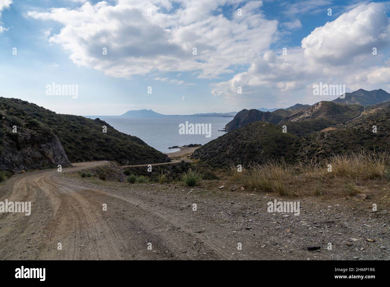 Une route de terre sinueuse menant à une plage isolée sur une côte ...
