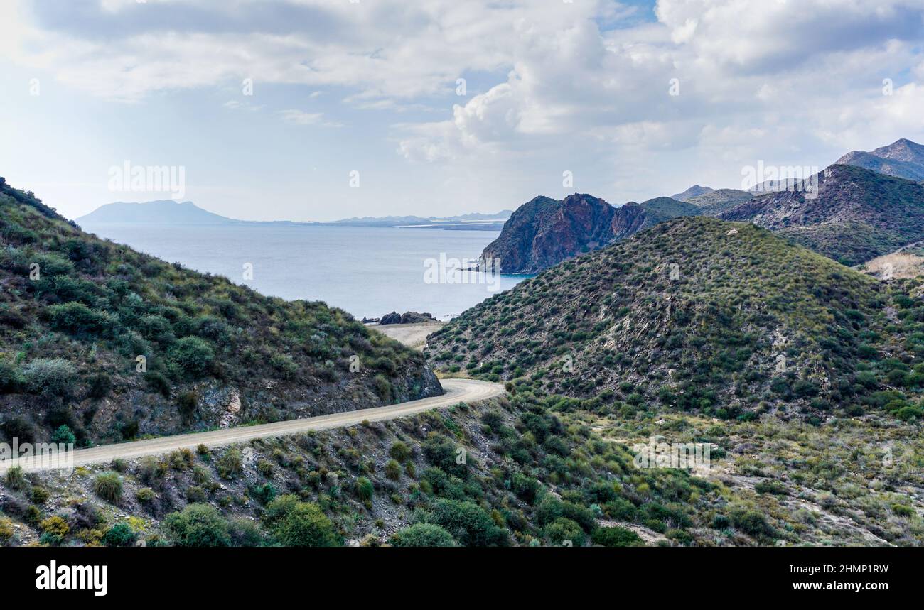 Une route de terre sinueuse menant à une plage isolée sur une côte ...