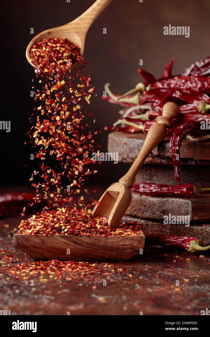 Les flocons de piment sont versés dans un plat en bois. Flocons de ...