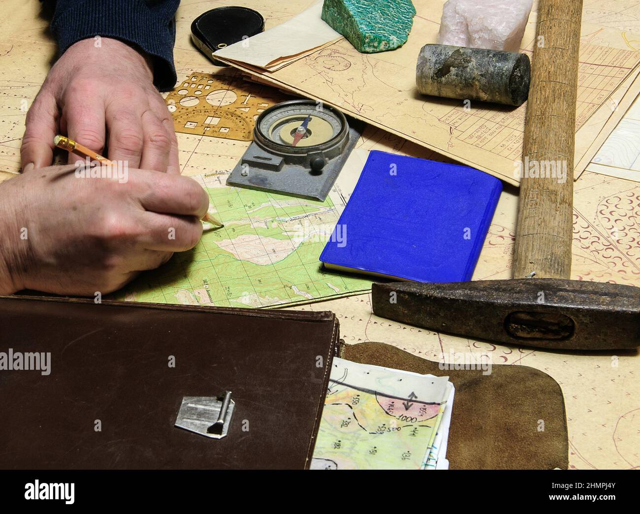 Le géologue travaille avec les cartes. Sur son bureau sont: Dossier de ...