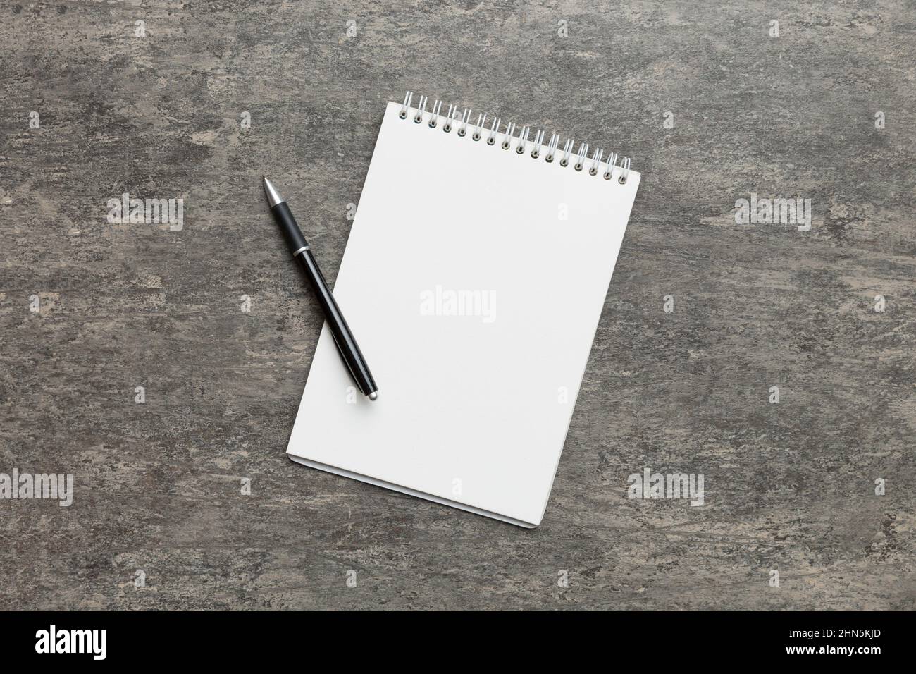 Bloc-notes vierge avec stylo sur fond blanc.Retour à l'école et concept ...