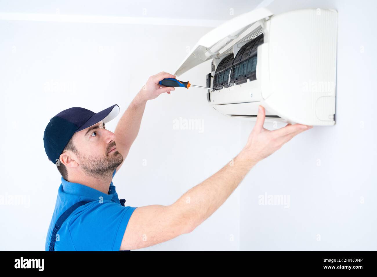Le technicien installe le climatiseur sur le mur à la maison pour l ...