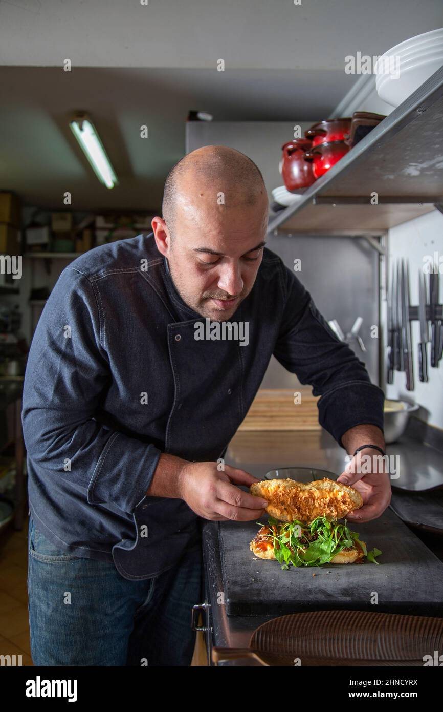 Un chef professionnel fait un délicieux sandwich avec des légumes verts ...