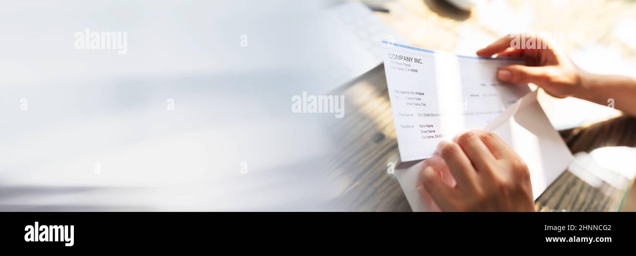 Chèque de paie dans l'enveloppe ouverte. Retenue du chèque de paie ...