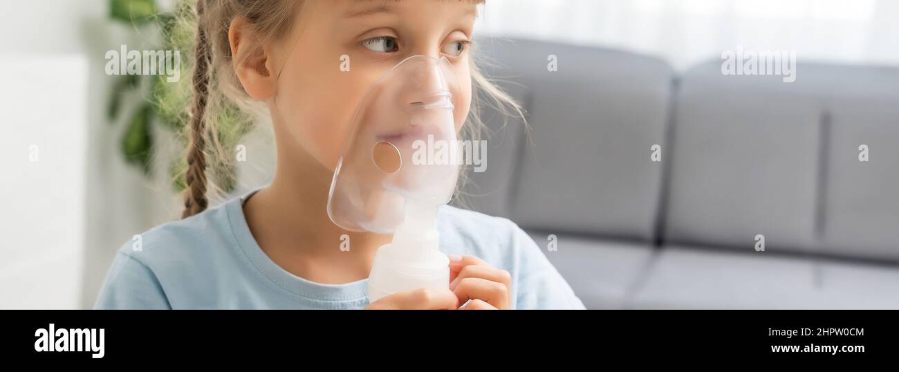 Enfant de neuf ans souffrant d'asthme allergique, inhalant son ...