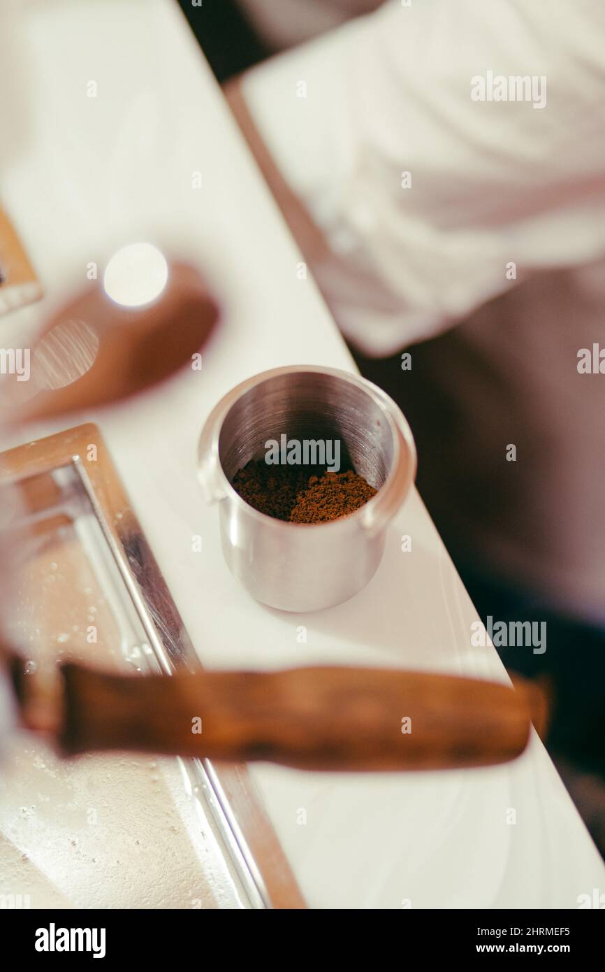 Petit foyer d'une main masculine préparant une tasse de café moulu avec ...