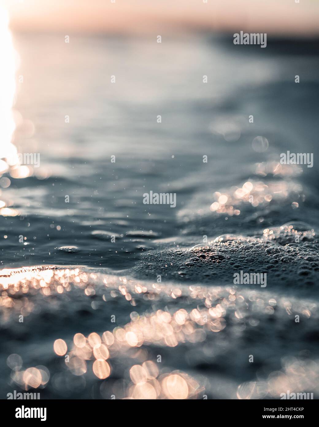 Prise de vue verticale des vagues de mer sous la lumière du soleil avec ...