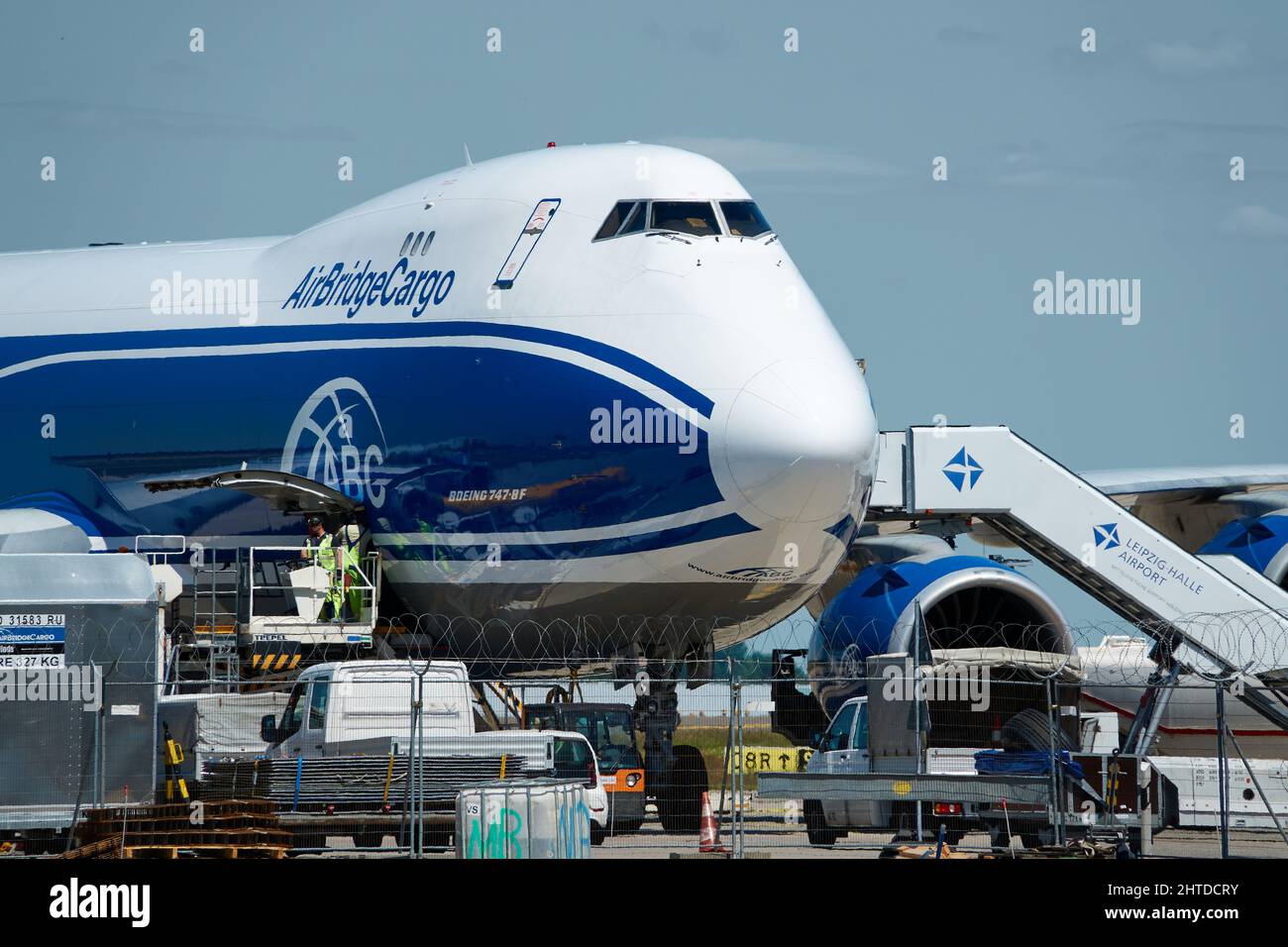 Avion cargo avec l'équipement de l'aéroport et les personnes de service ...