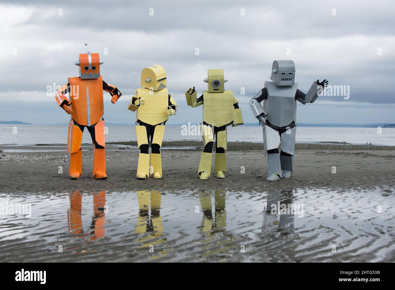 Famille de robots colorés marchant sur la plage. Des robots heureux qui ...