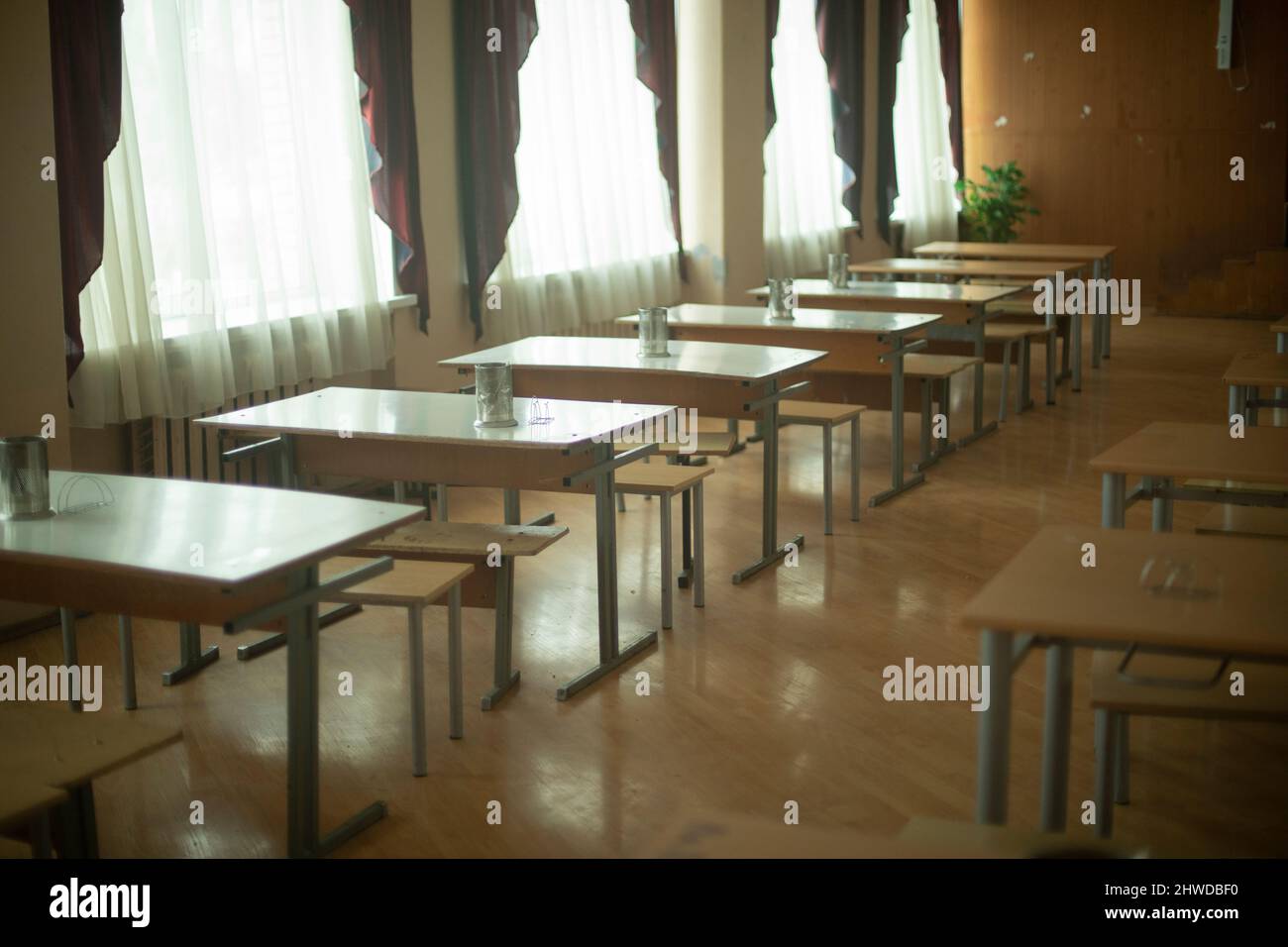 Tables dans la cantine scolaire. Les tables avec bancs sont rangées ...