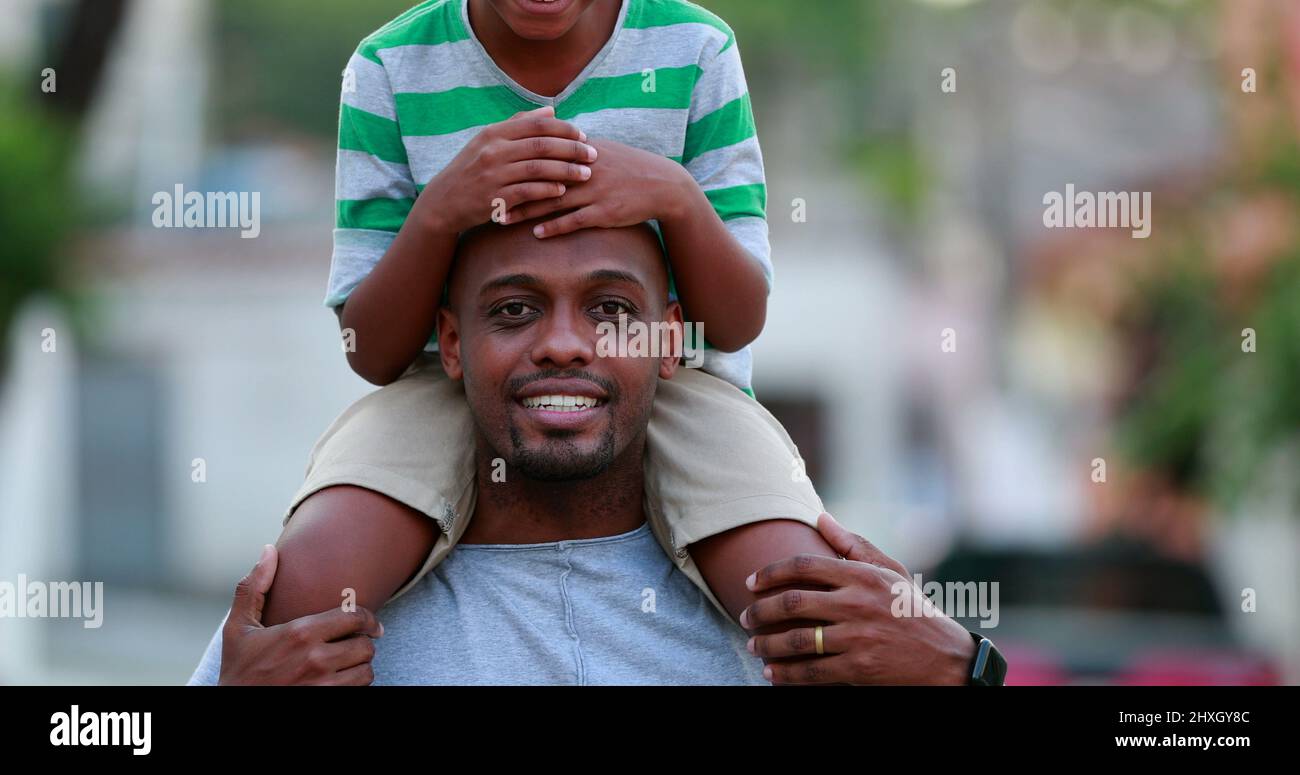Fils sur les épaules du père. Joyeux enfant africain et papa se liant à l'extérieur Photo Stock ...