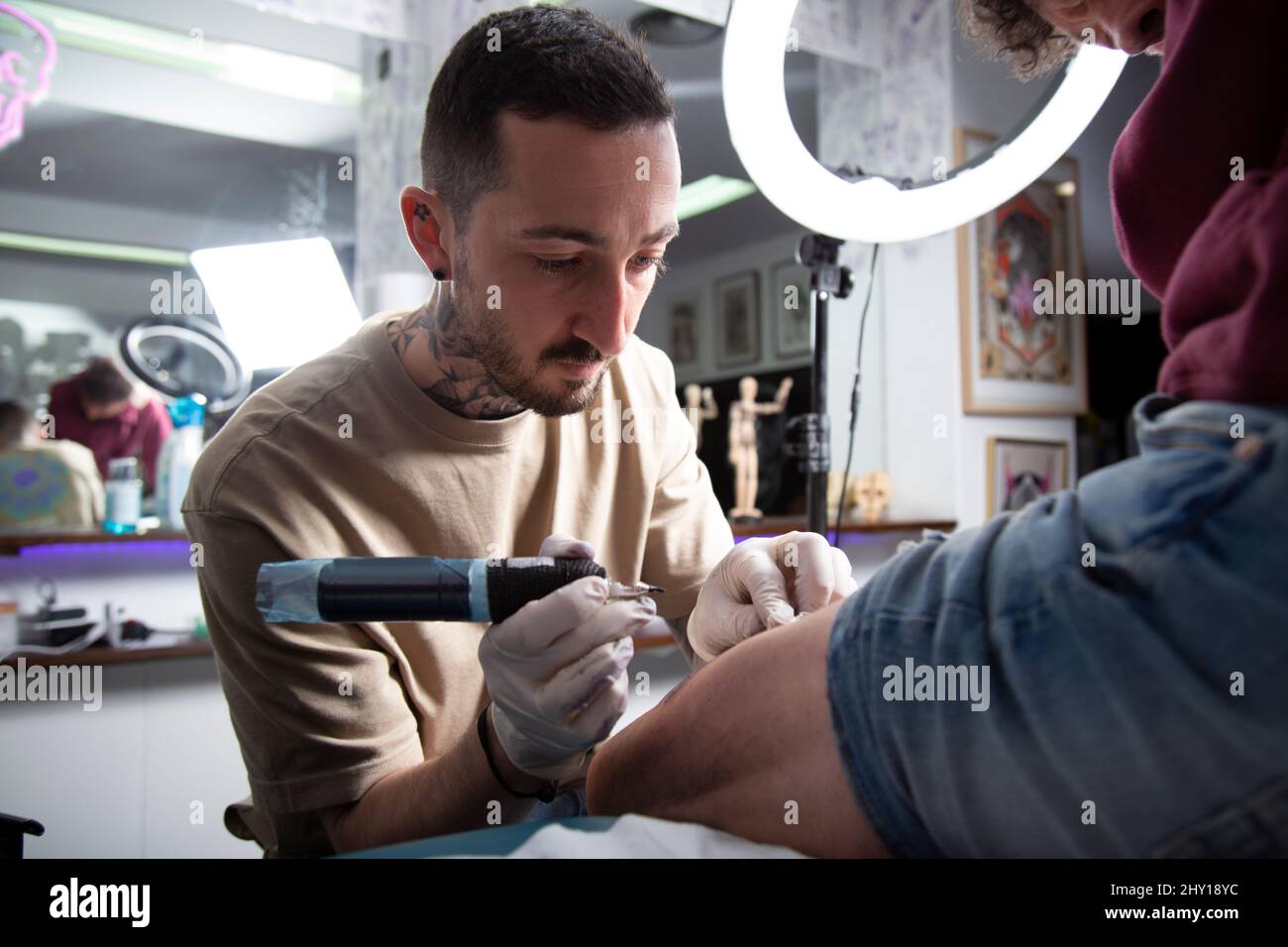 Maître de tatouage professionnel en gants de latex faisant tatouage sur ...