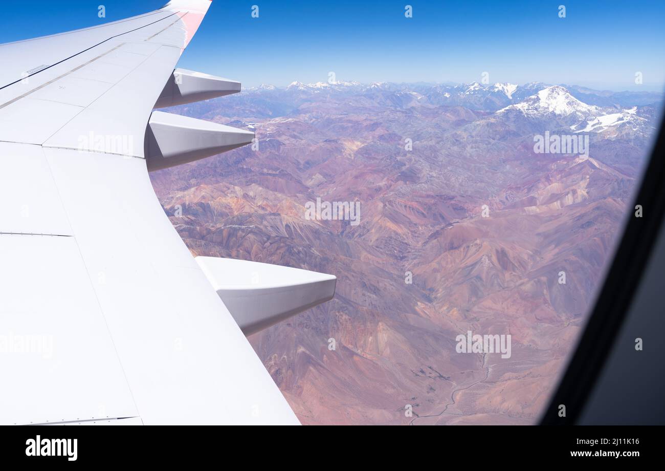 Aile blanche de la fenêtre de l'avion avec chaîne de montagnes des ...