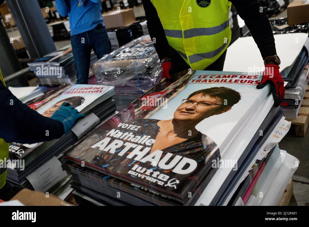 Deux hommes portent des affiches de la candidate Nathalie Arthaud dans ...